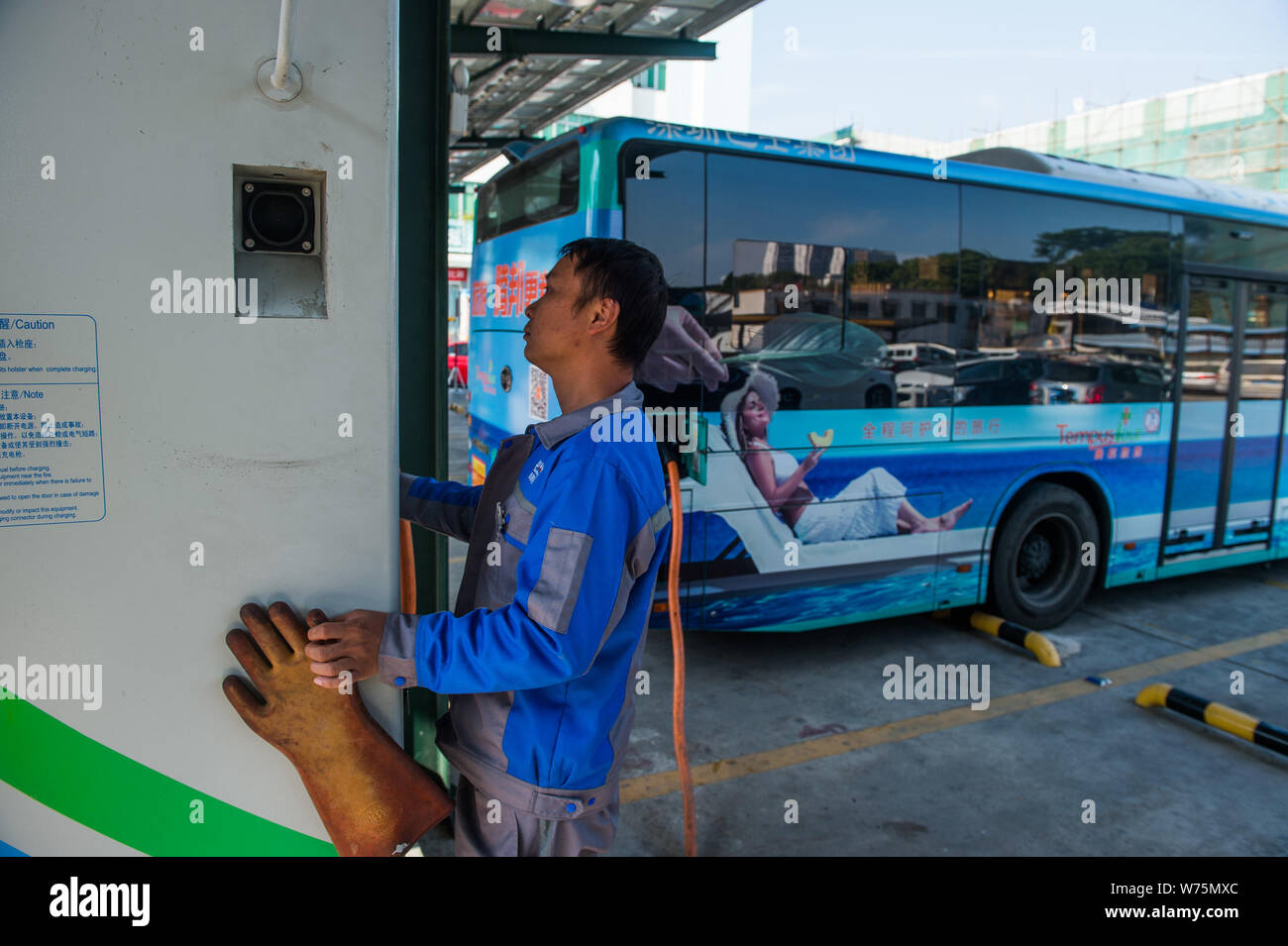 --FILE--A Chinese worker prepares to recharge an electric bus at a ...