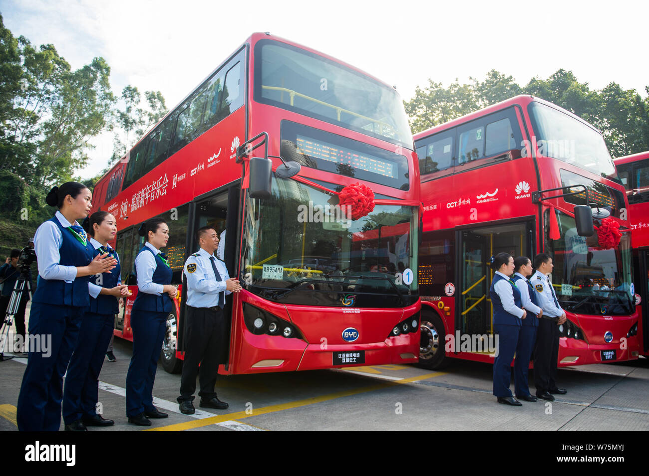 --FILE--Chinese bus drivers and stewardesses pose by newly-delivered ...