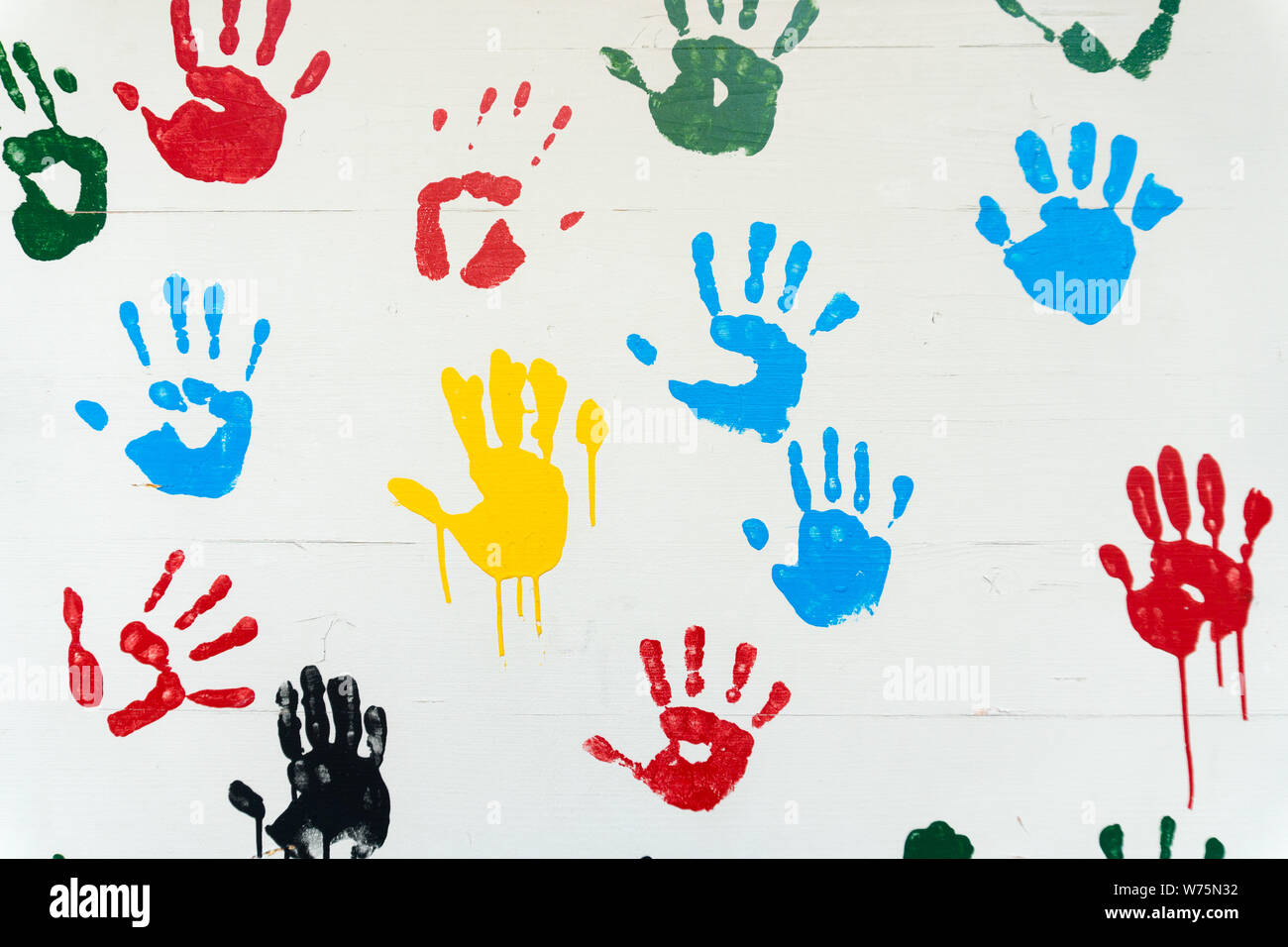 many sets of bright cheerful handprints in many colors on a white ...