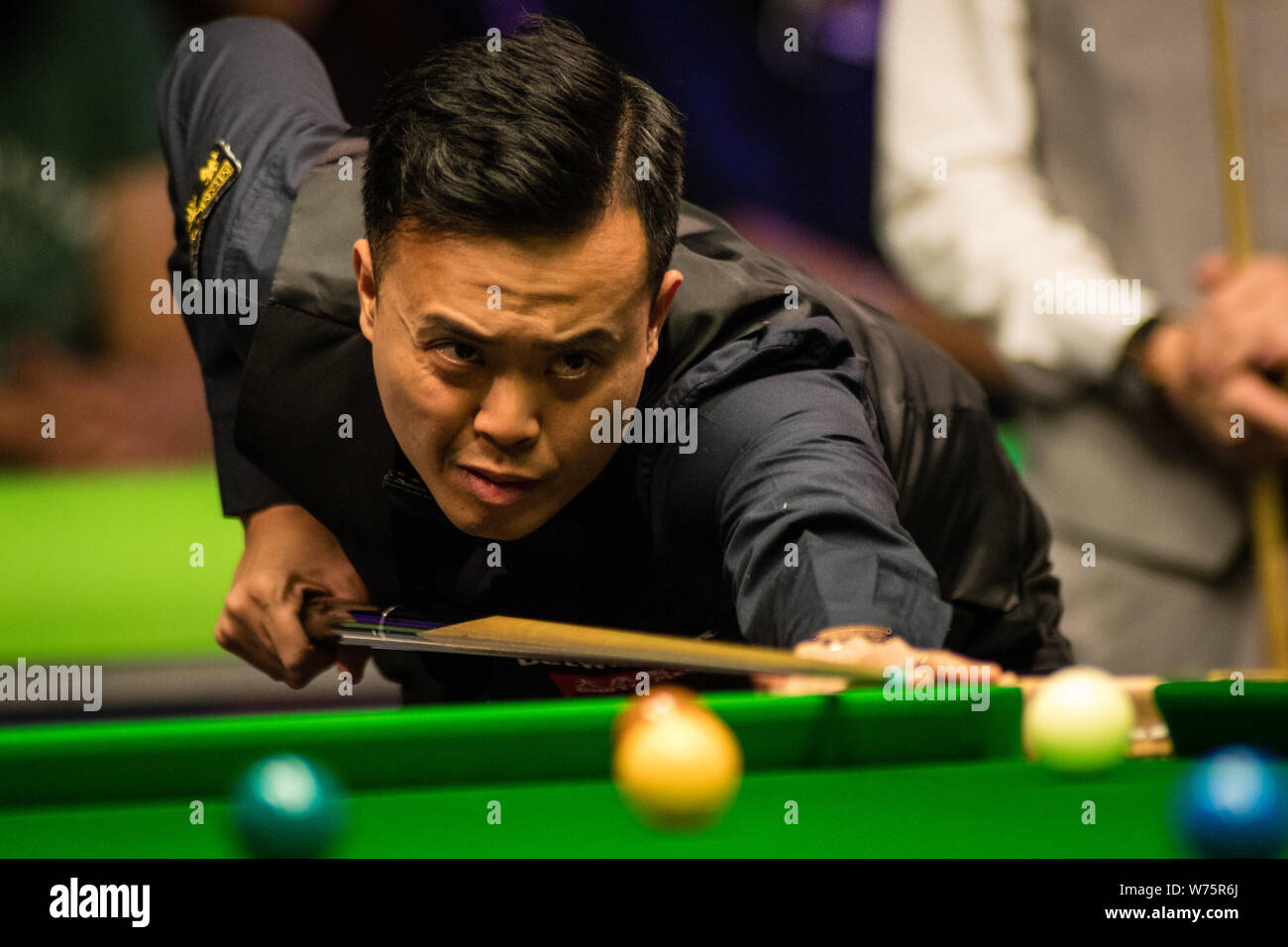 Marco Fu of Hong Kong plays a shot to Zhao Xintong of China in their ...