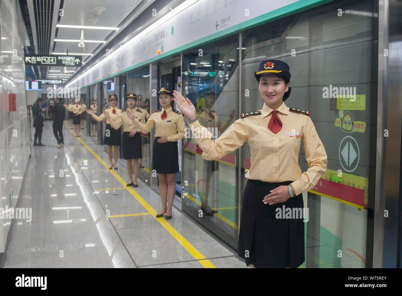 Chinese female staff members pose at the Huadu Moter City Subway ...