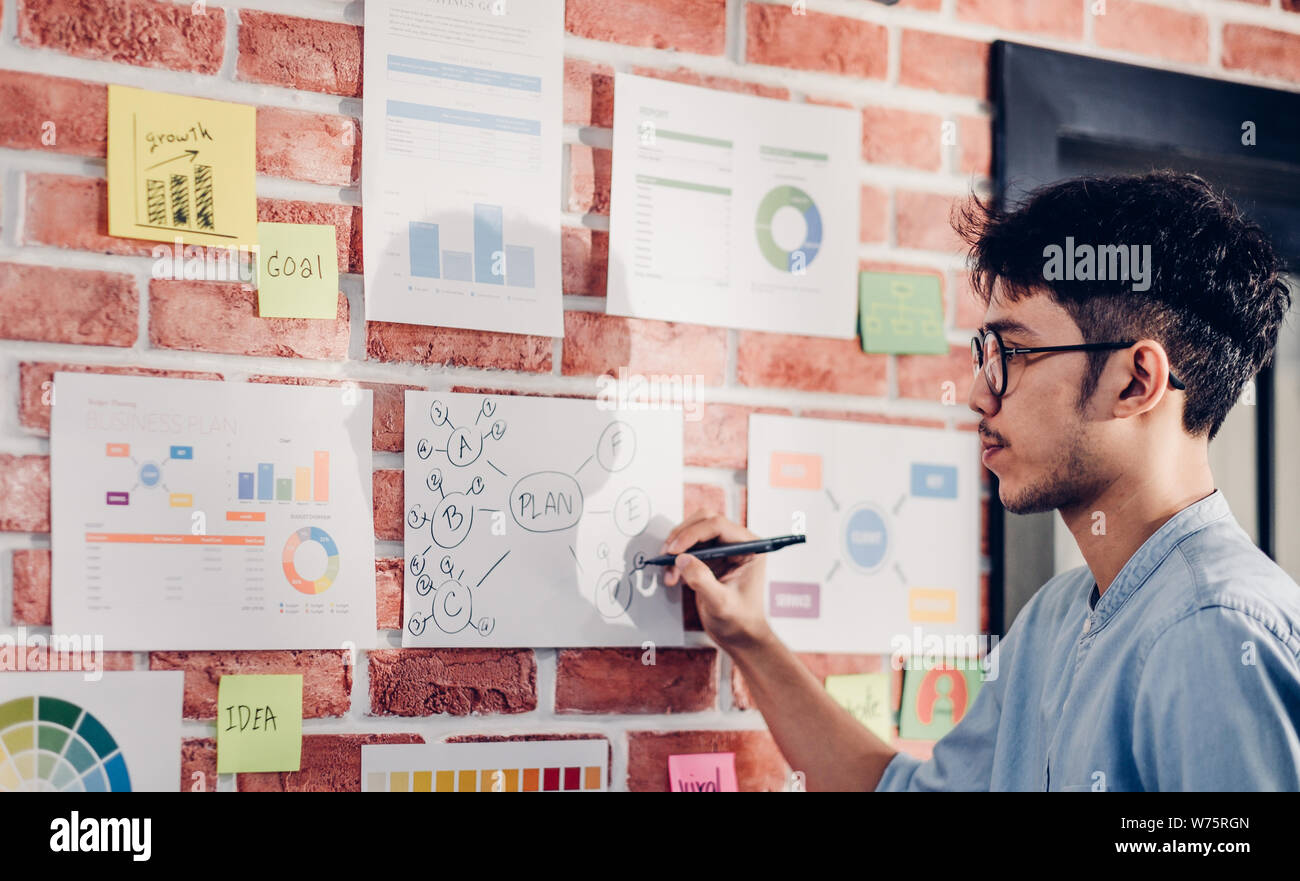 Asian man creative director designer writing plan at data chart and ...