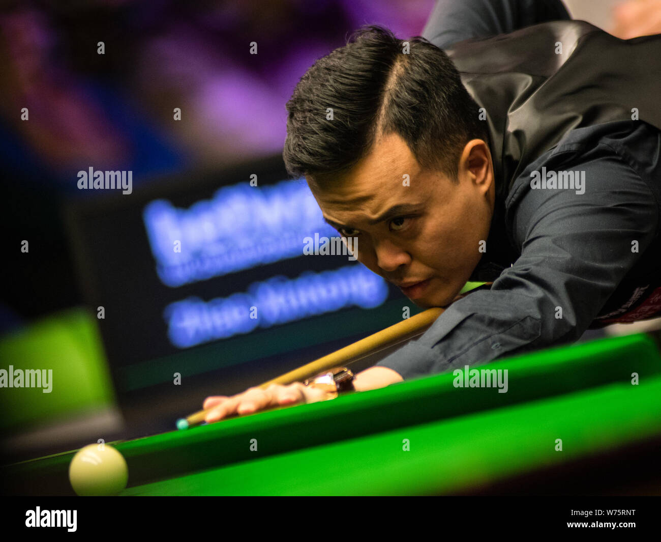 Marco Fu of Hong Kong plays a shot to Zhao Xintong of China in their ...