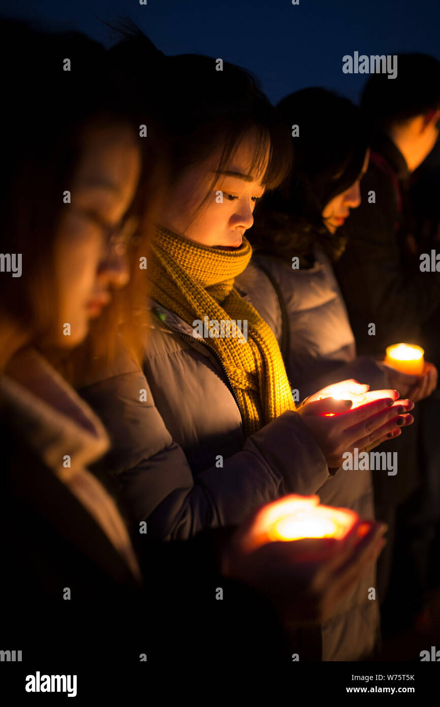 Chinese students hold candles during a candlelight vigil to mourn the ...