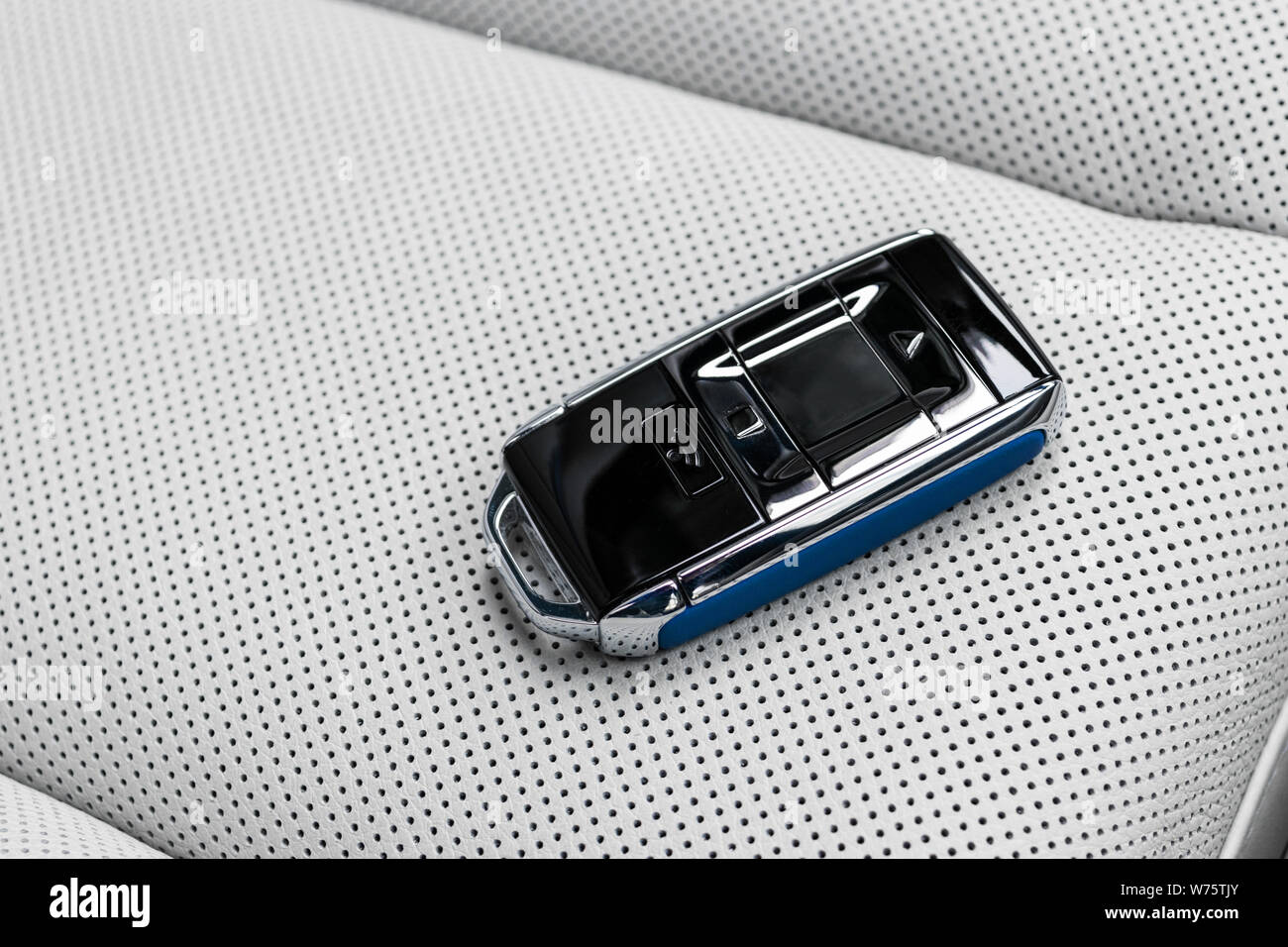 Closeup inside vehicle of wireless blue leather key ignition on white ...
