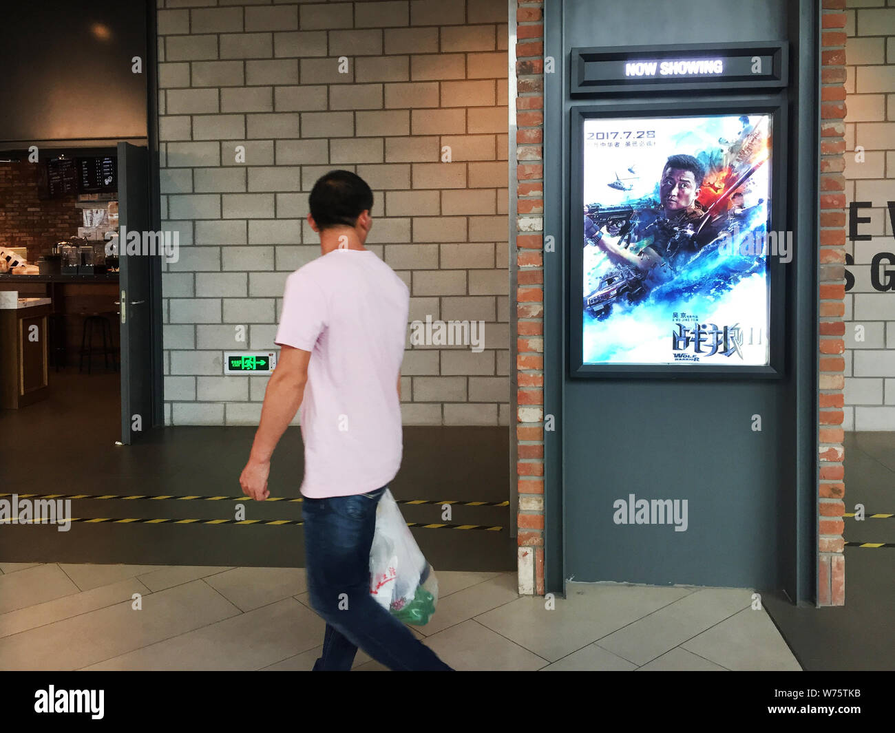 --FILE--A Chinese film goer looks at a poster of the Chinese action ...