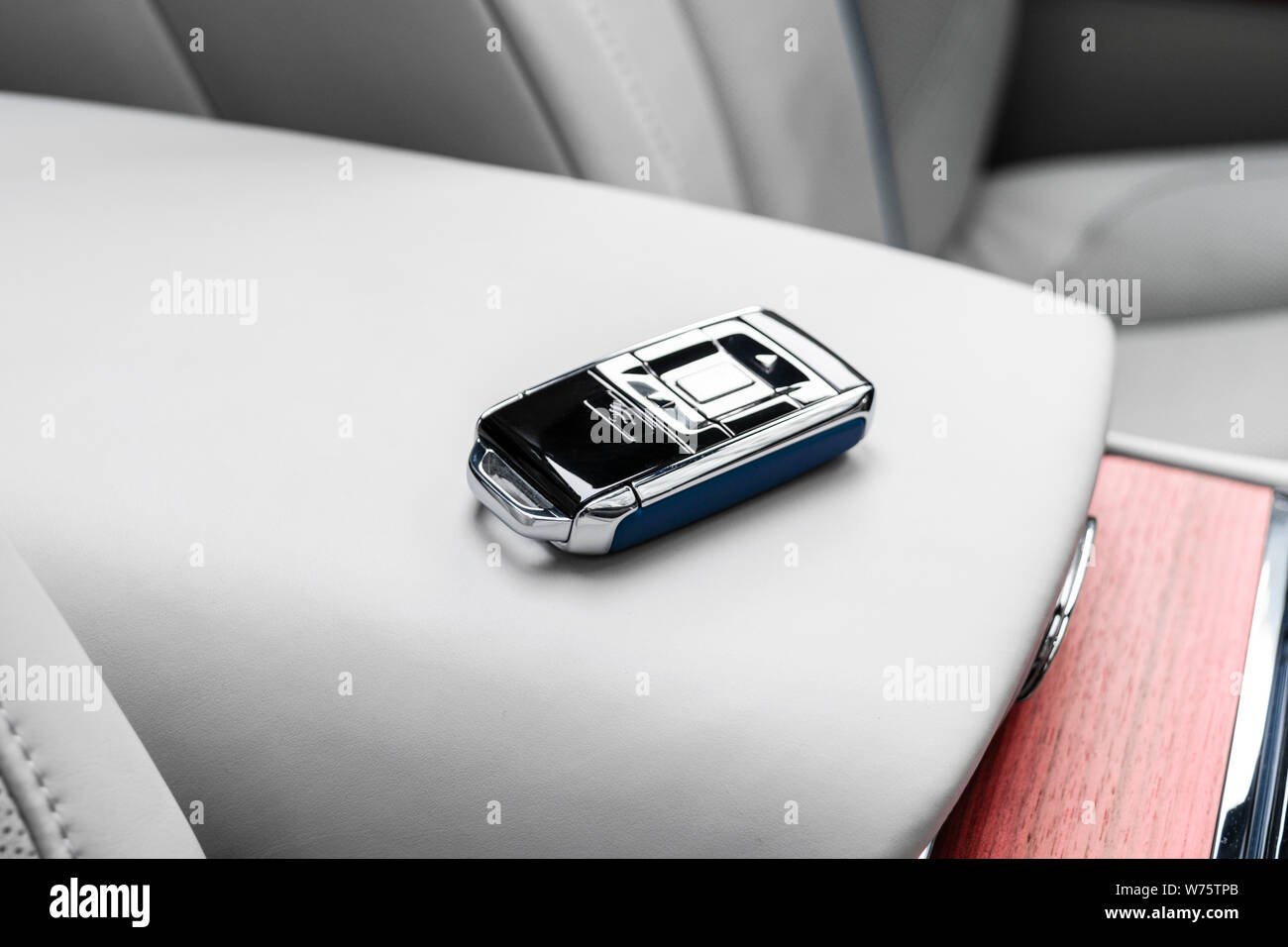 Closeup inside vehicle of wireless blue leather key ignition on white ...