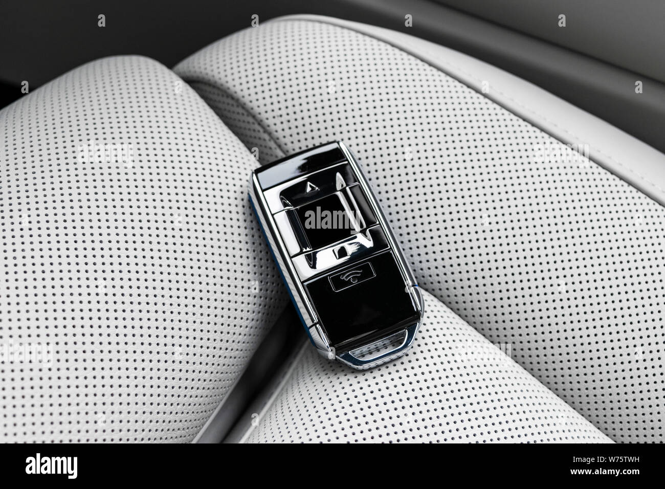 Closeup inside vehicle of wireless blue leather key ignition on white ...