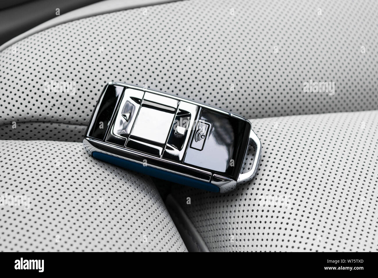 Closeup inside vehicle of wireless blue leather key ignition on white ...