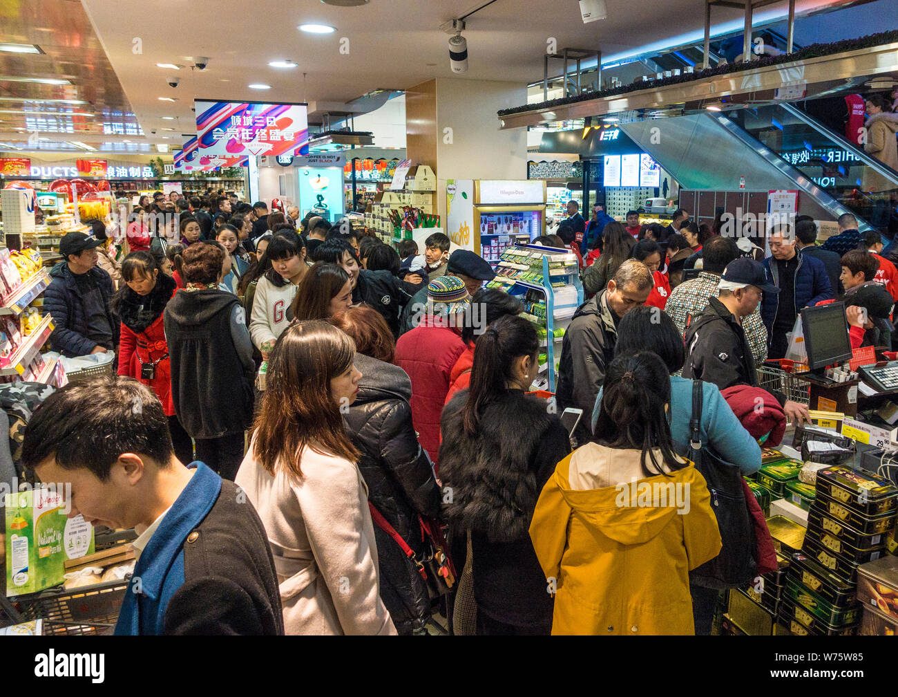 Chinese customers queue up to pay their purchases at a supermarket ...