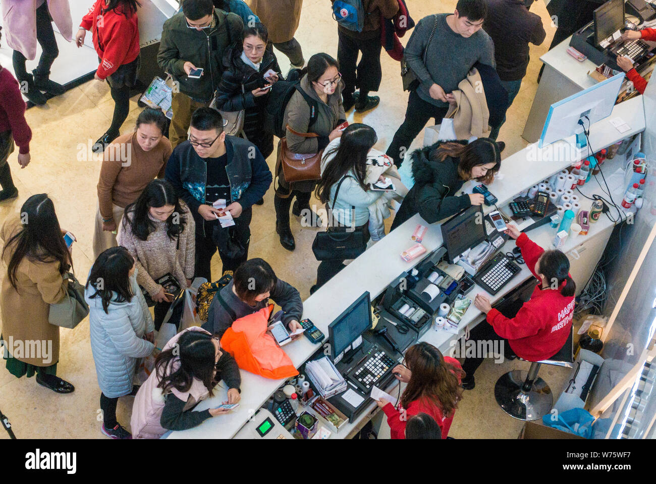 Chinese customers queue up to pay their purchases at a shopping mall ...