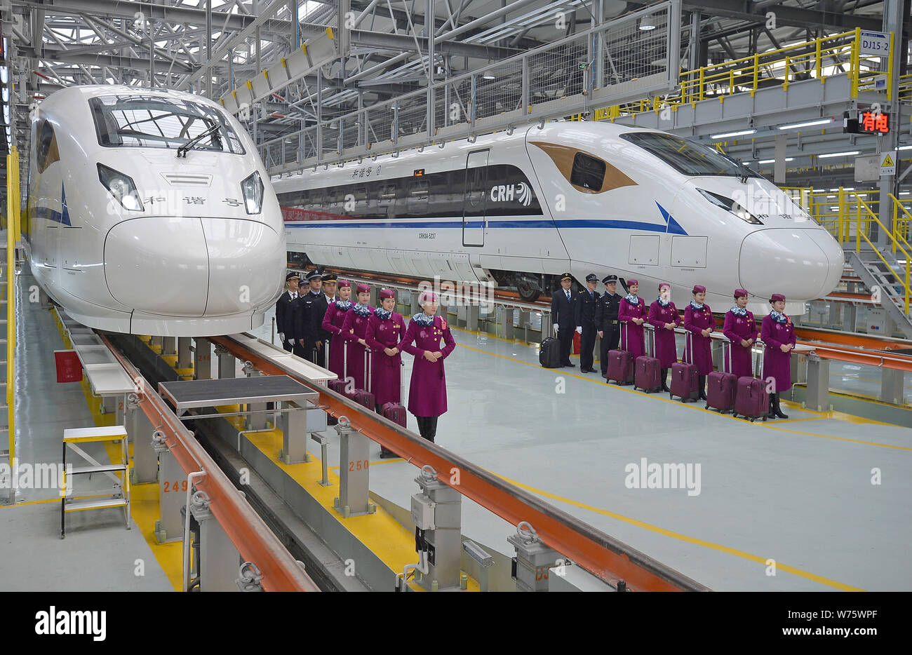 Crew members pose for photos in front of CHR (China High-speed Railway ...