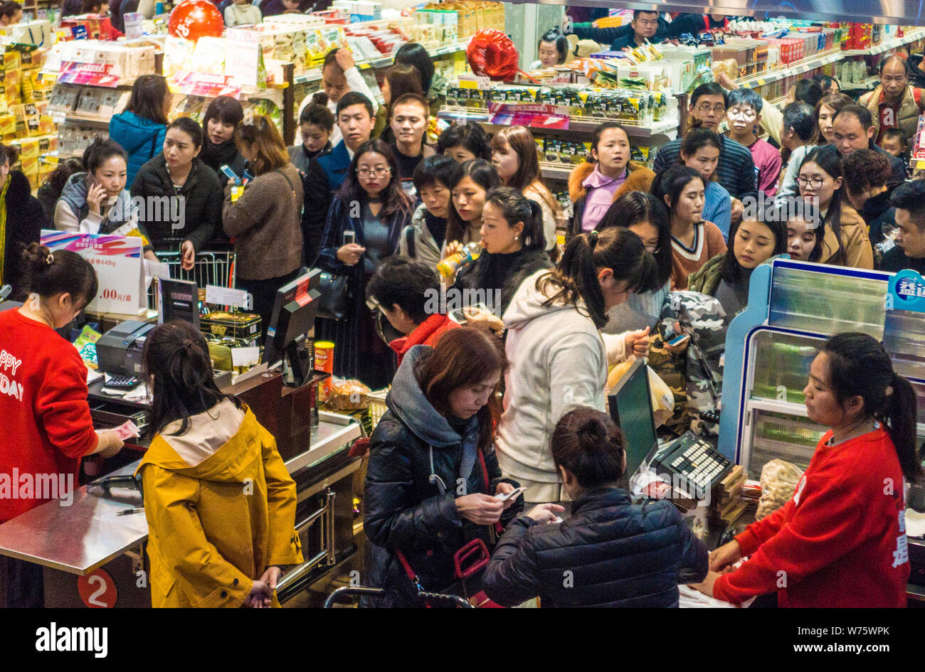 Chinese customers queue up to pay their purchases at a supermarket ...