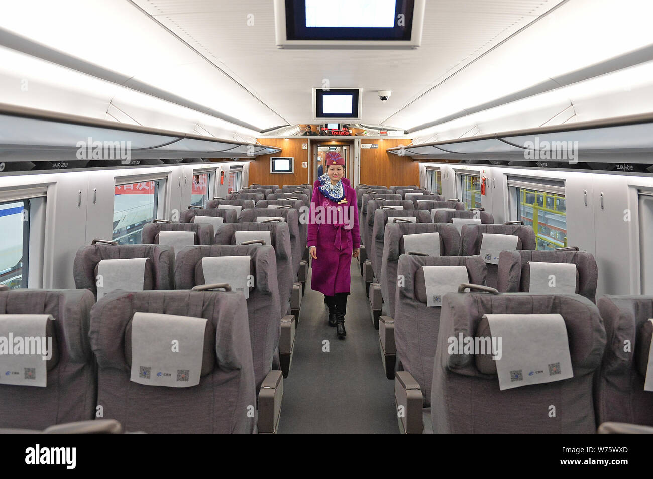 Crew members pose for photos in a CHR (China High-speed Railway) bullet ...