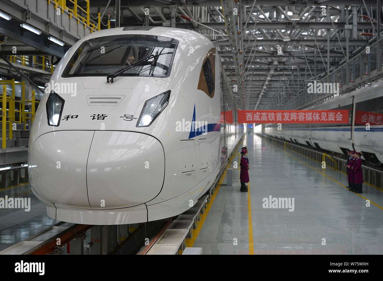 Crew members pose for photos in front of CHR (China High-speed Railway ...