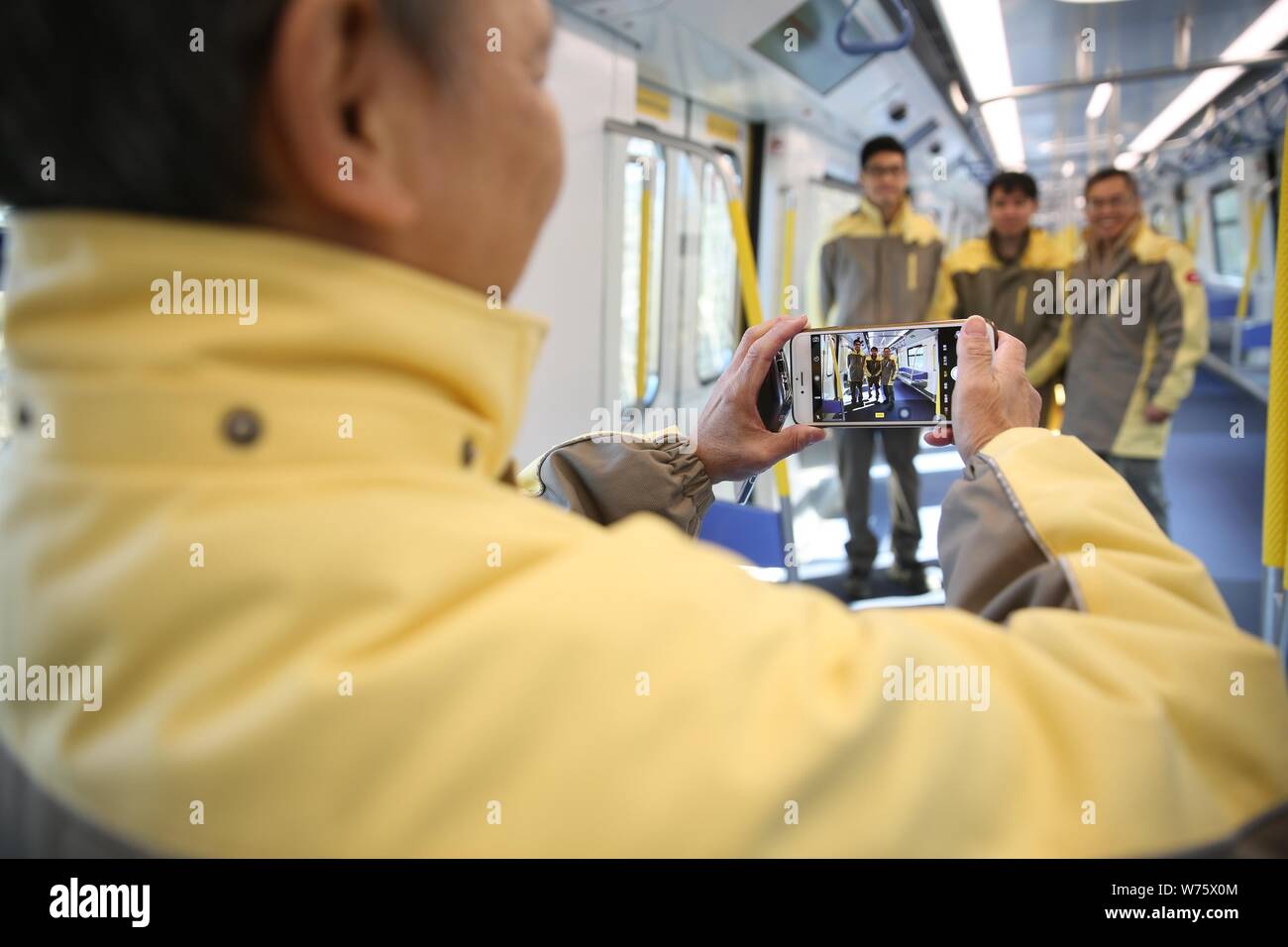 Employees of the Hong Kong transportation company MTR Corp are seen in ...