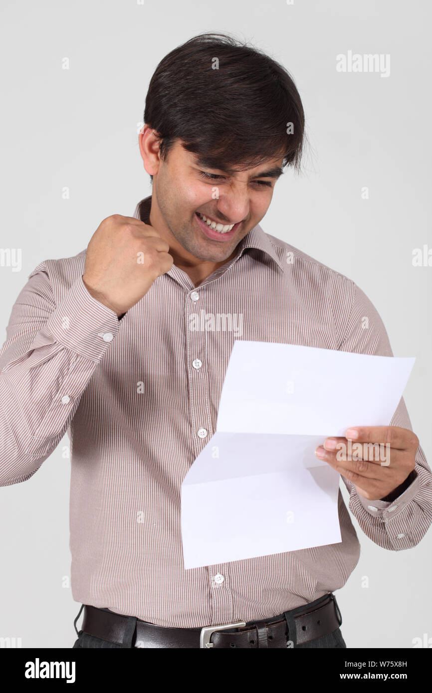 Young man reading an appointment letter and punching the air Stock ...