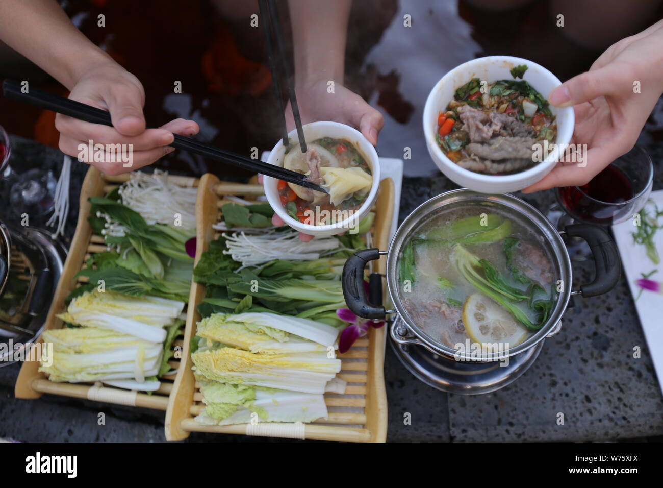 Customers have hot pot meals while taking a health bath in a hot spring ...