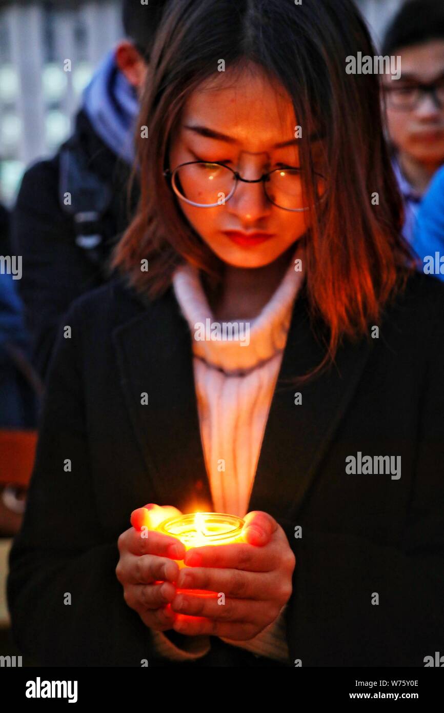 A Chinese student holds a candle during a candlelight vigil to mourn ...