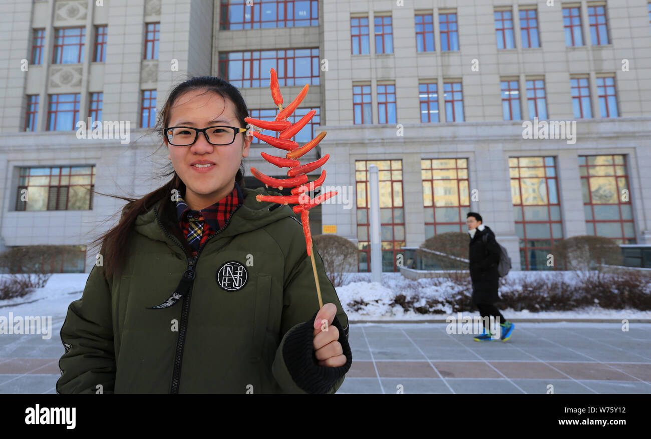 A student poses with a unique tanghulu, also called bingtanghulu, which ...