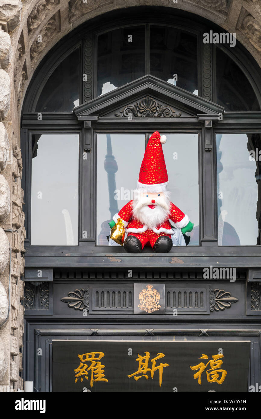 A Santa Claus decoration is displayed on the surface of a building on ...