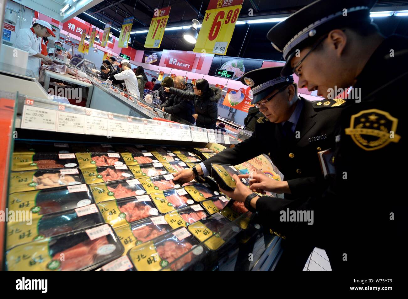 --FILE--Chinese law enforcement officers check the quality of meat at a ...
