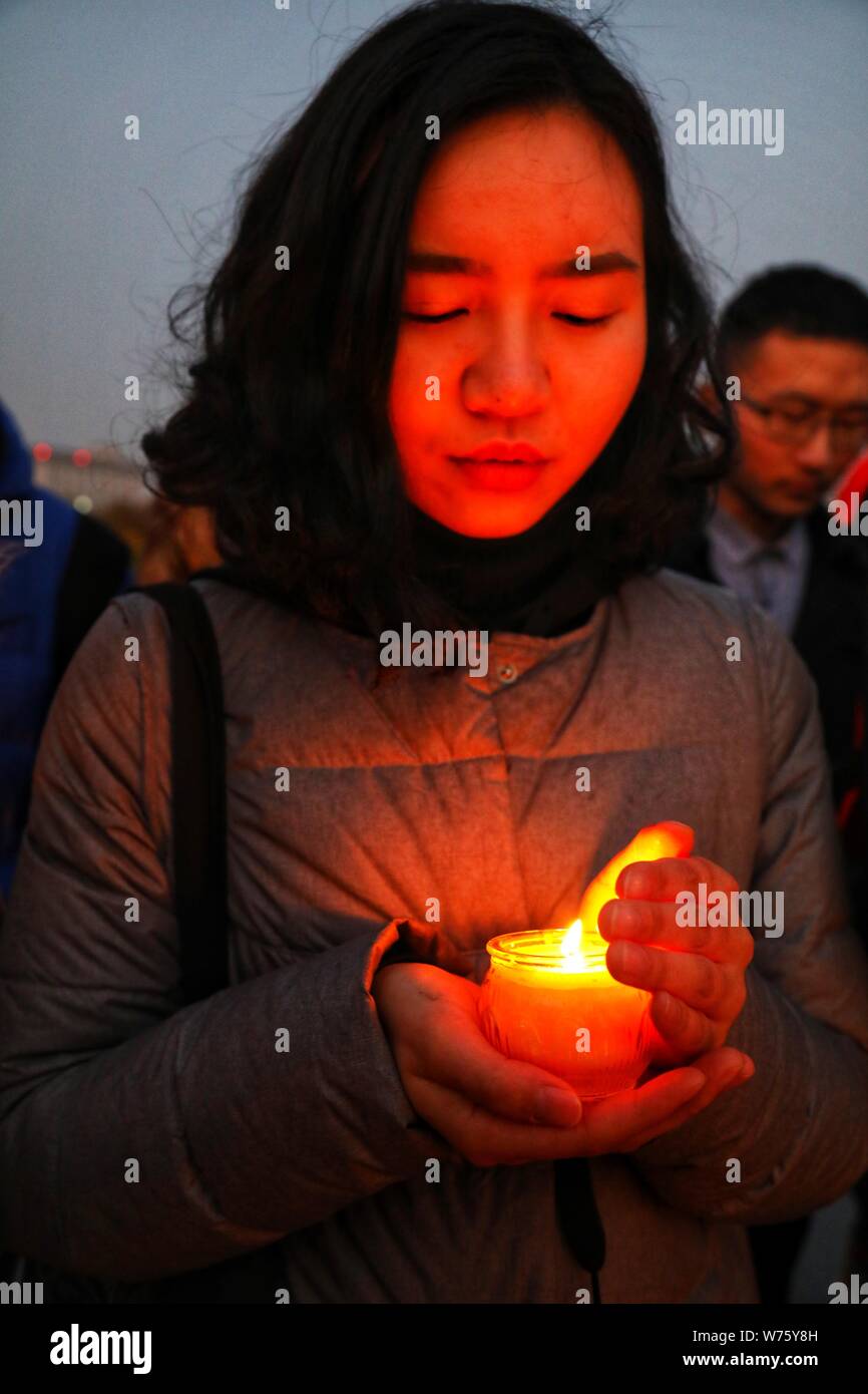 A Chinese student holds a candle during a candlelight vigil to mourn ...