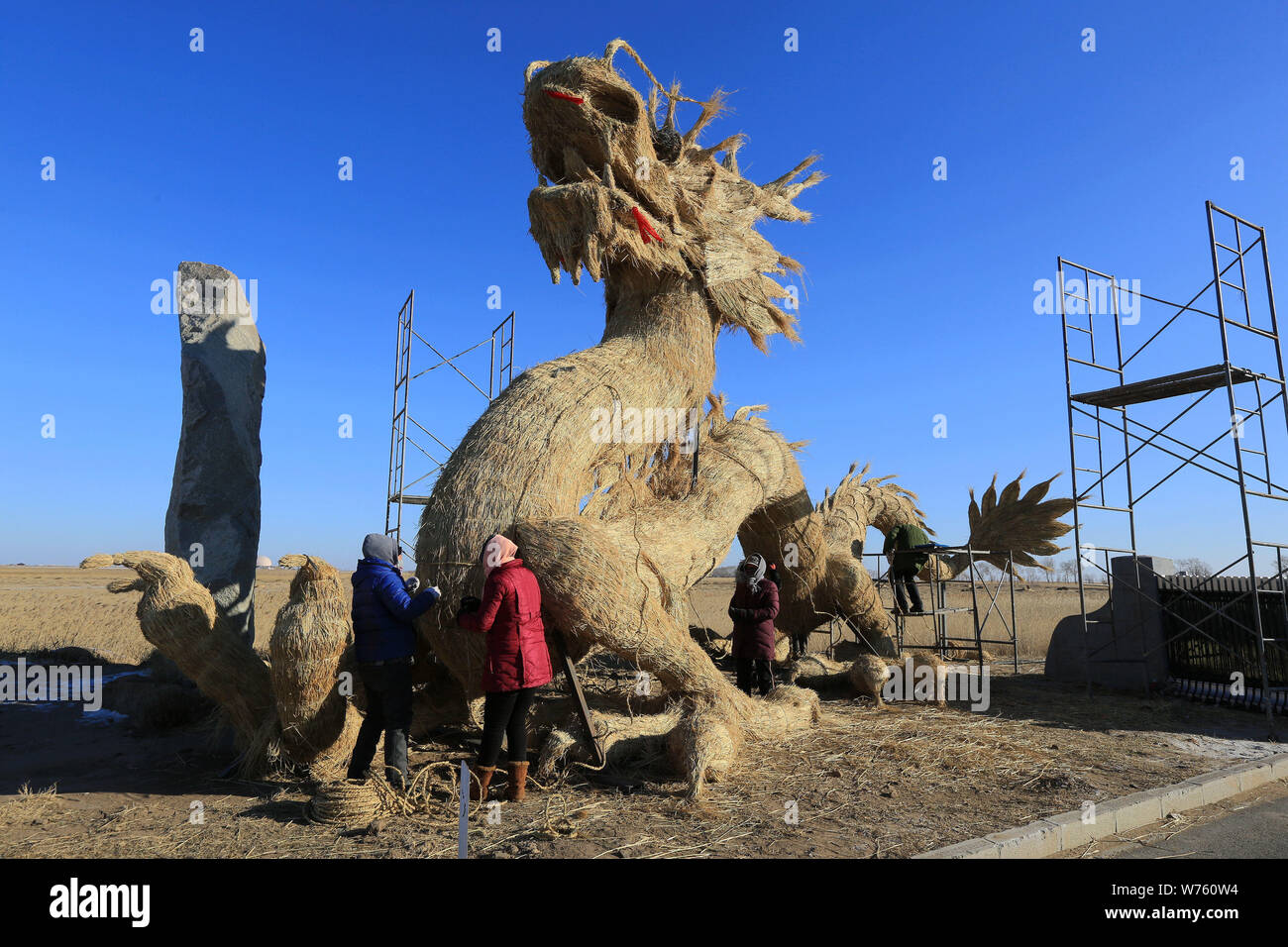 Chinese workers build two dragons made of straw, which are said to be ...