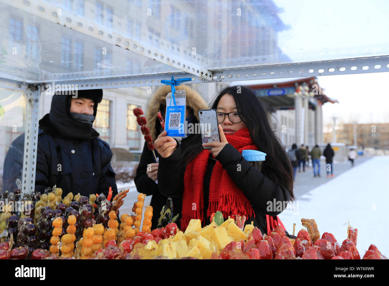 A student uses her smartphone to scan the QR code through mobile ...