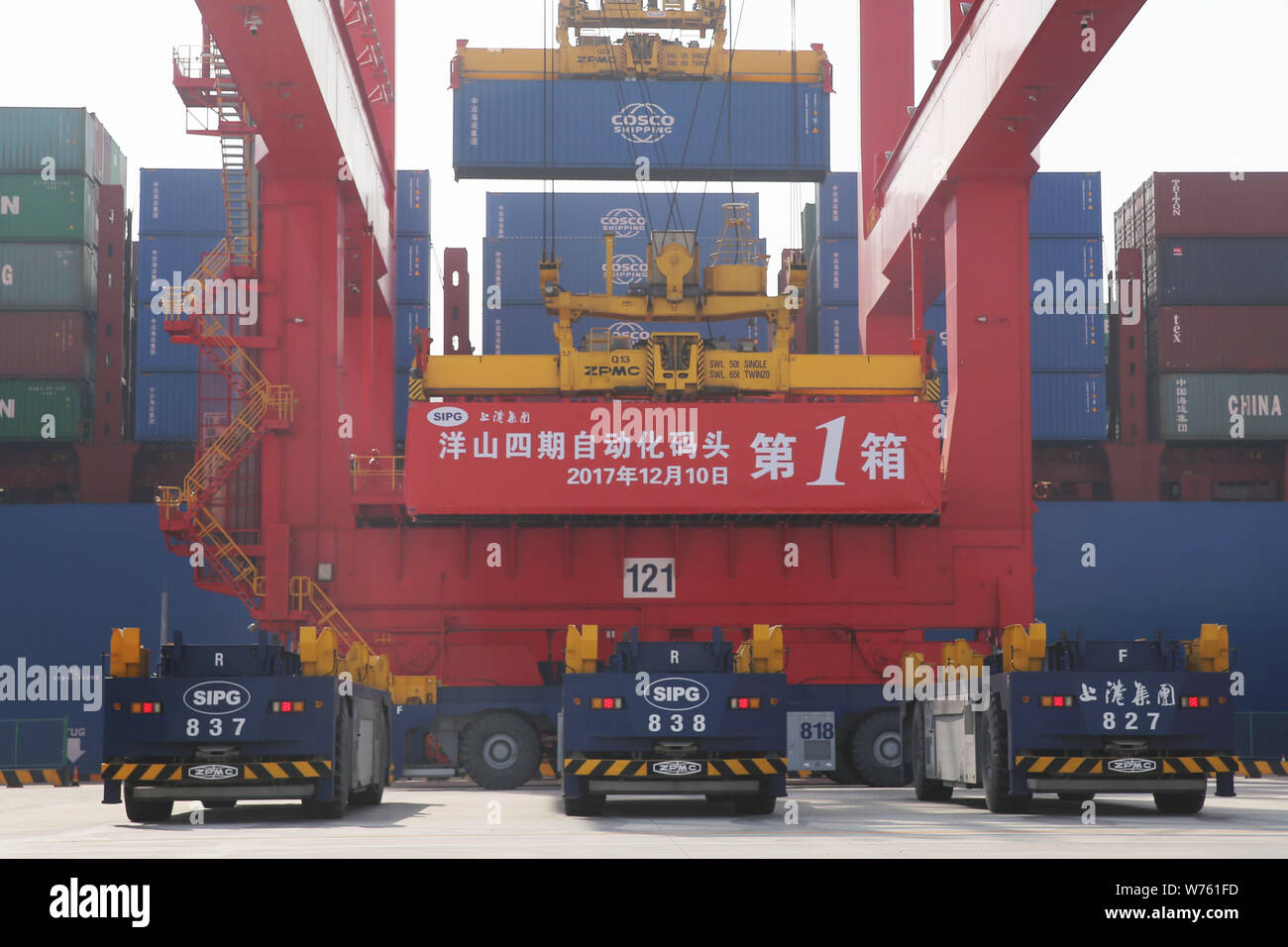 A crane vehicle lifts a container of COSCO to be shipped abroad from an ...