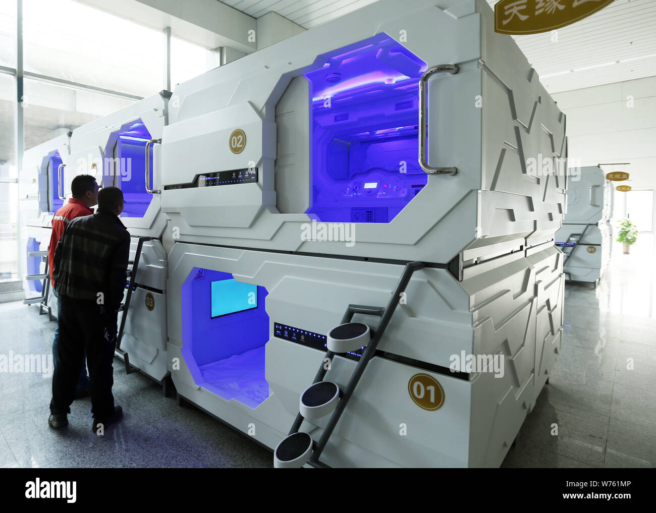 Passengers look at sleeping capsules in the arrival hall of Terminal 3 ...