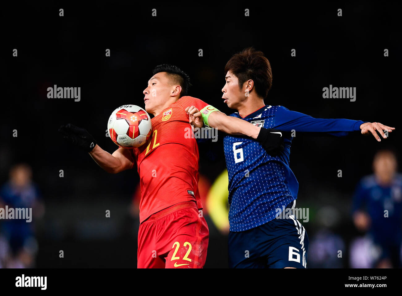 Yu Dabao, left, of China kicks the ball to make a pass against Miura ...