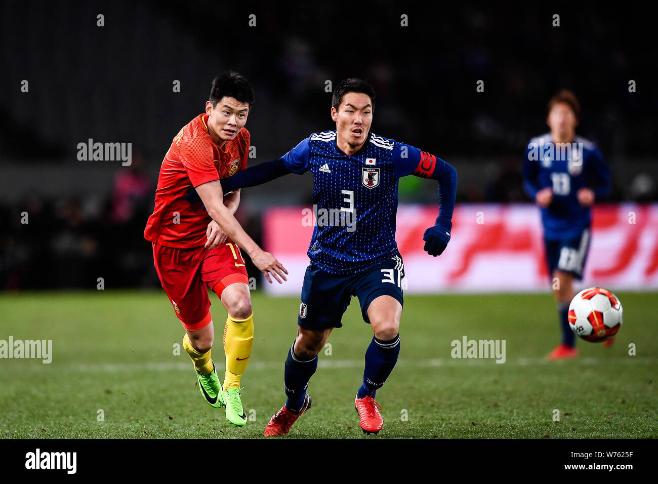 Shoji Gen, right, of Japan kicks the ball to make a pass against Zhang Wenzhao of China during ...