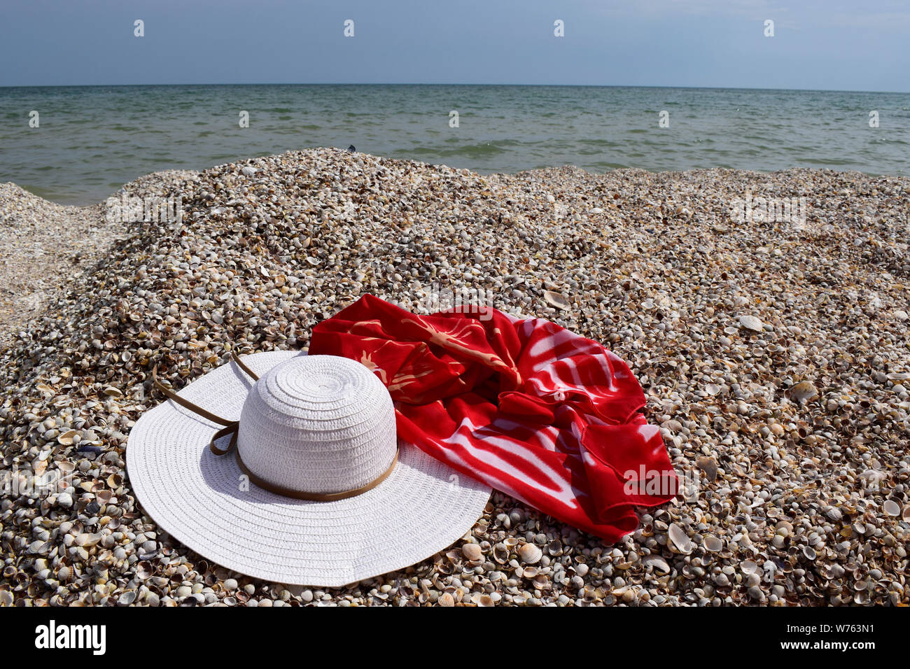Vintage summer straw beach hat and pareo on the seashore. Accessories ...