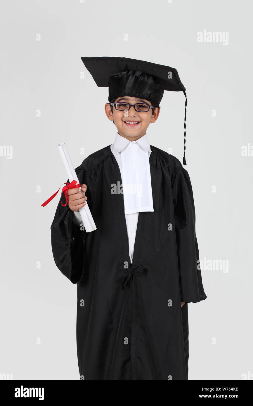Boy in graduation gown holding a degree Stock Photo - Alamy