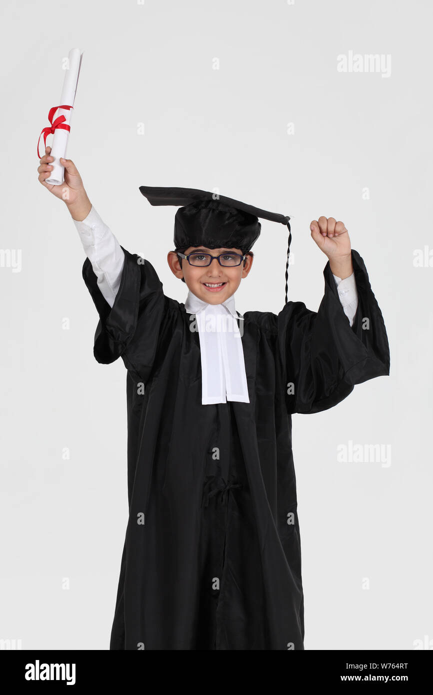 Boy in graduation gown holding a degree Stock Photo - Alamy