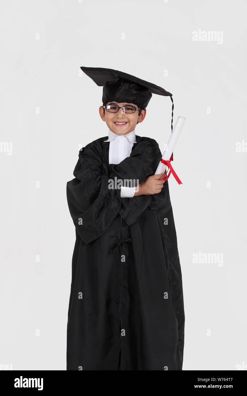 Boy in graduation gown holding a degree Stock Photo - Alamy
