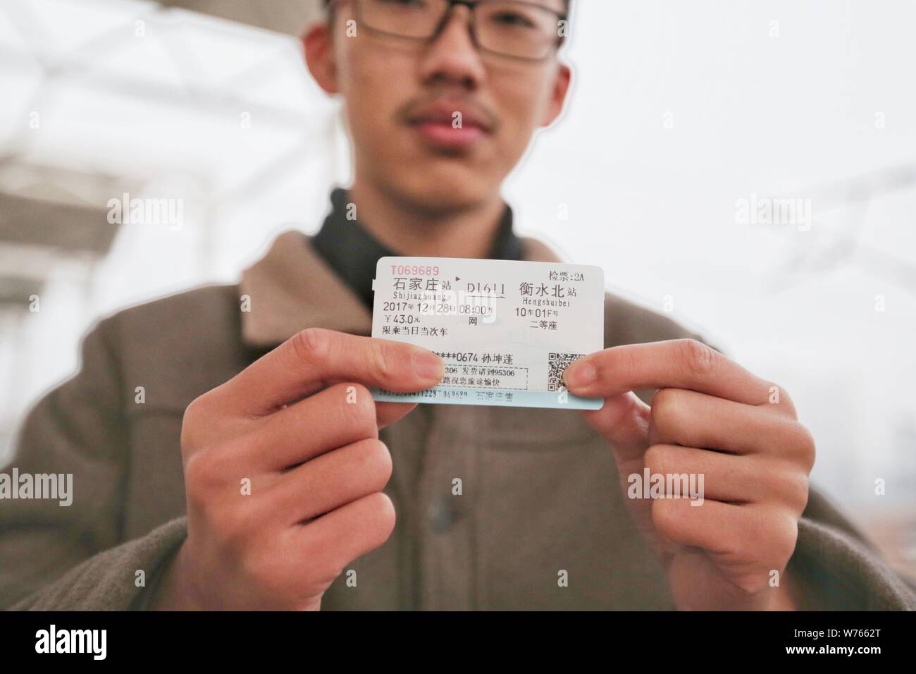 A passenger shows his high-speed railway bullet train ticket on the ...