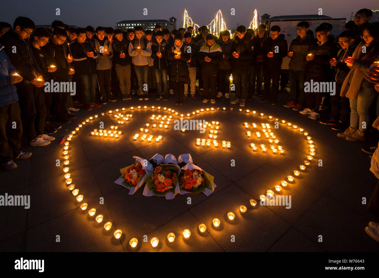 Chinese students hold candles during a candlelight vigil to mourn the ...