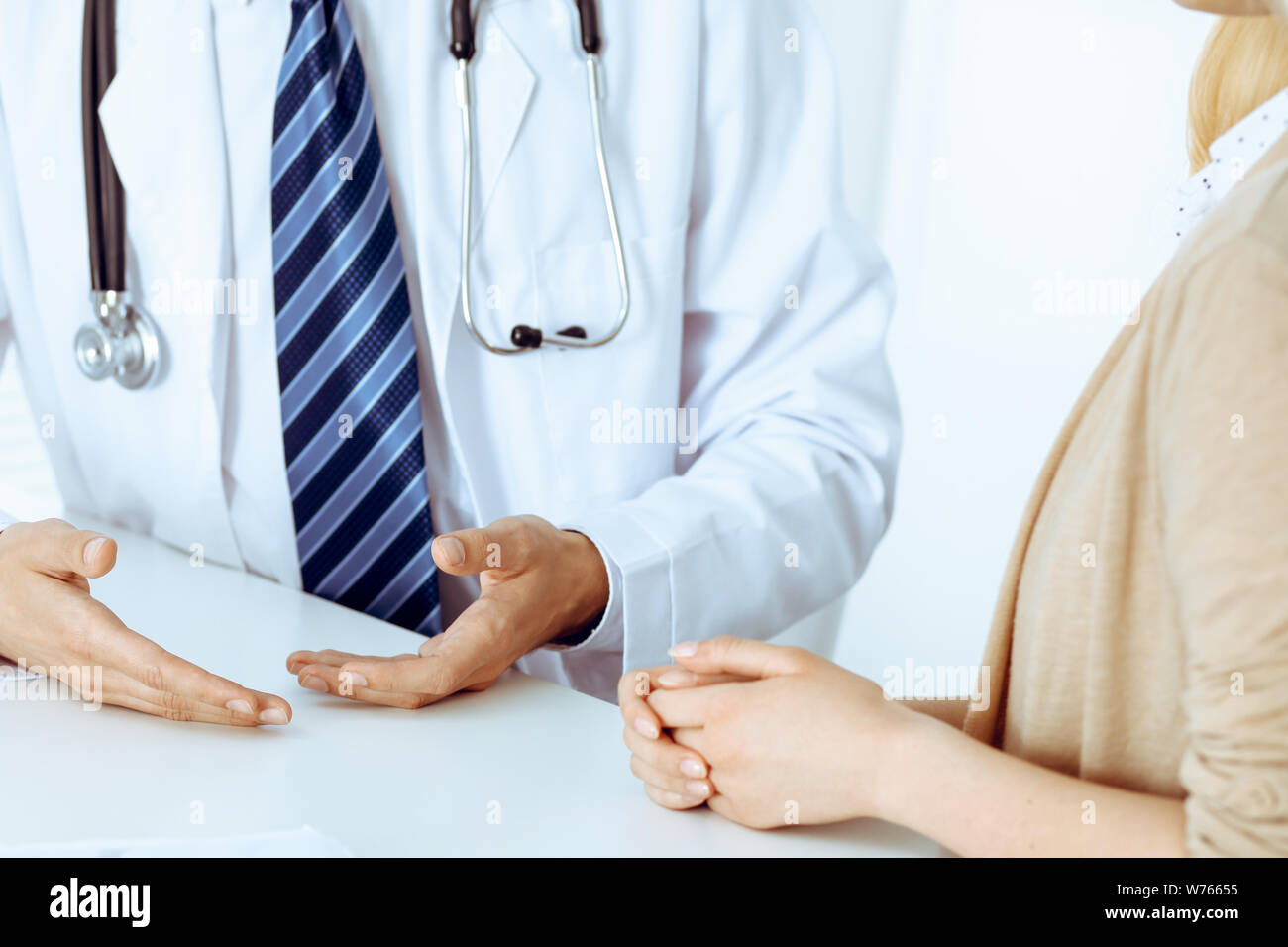 Hand of doctor reassuring her female patient. Concepts of medical ...