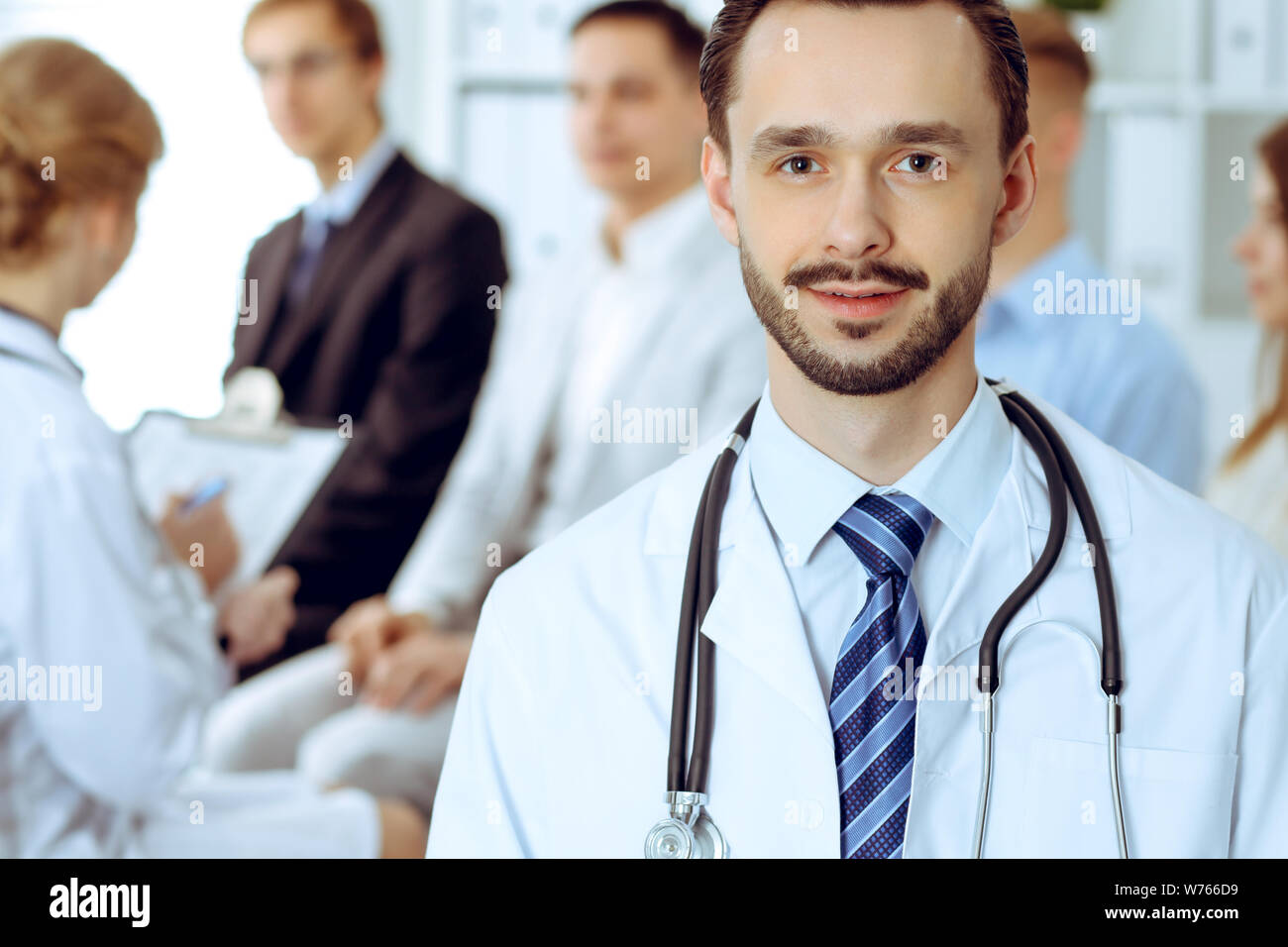 Doctor smiling against of group of patients and nurse. Best treatment ...