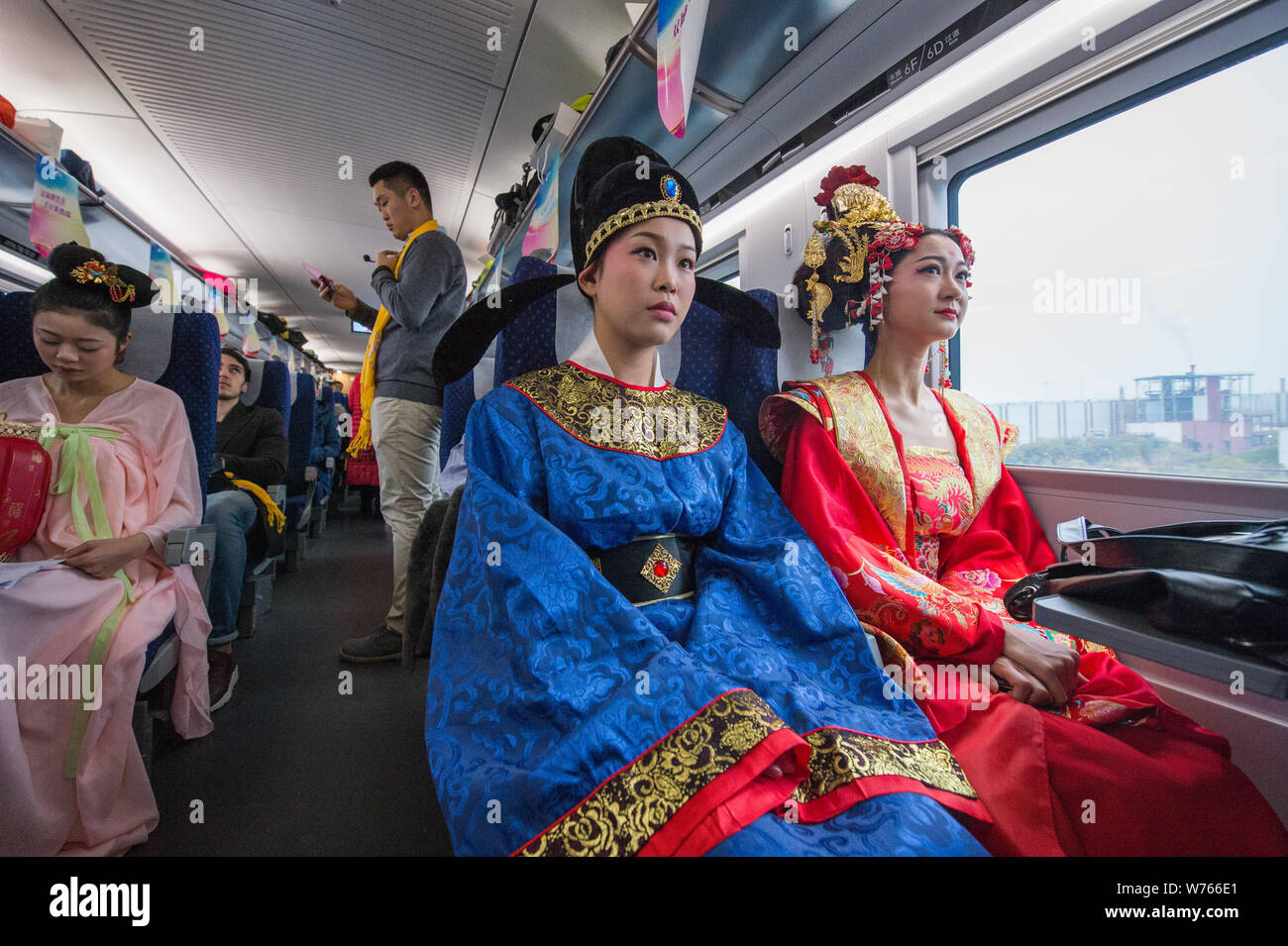 Performers in Chinese ancient costumes sit in a CRH (China Railway High ...