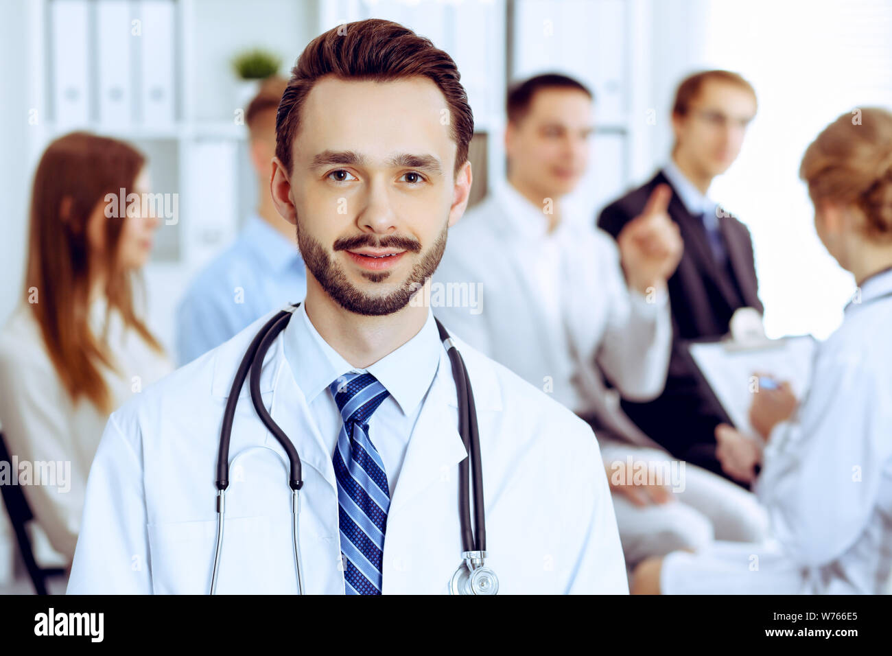 Doctor smiling against of group of patients and nurse. Best treatment ...