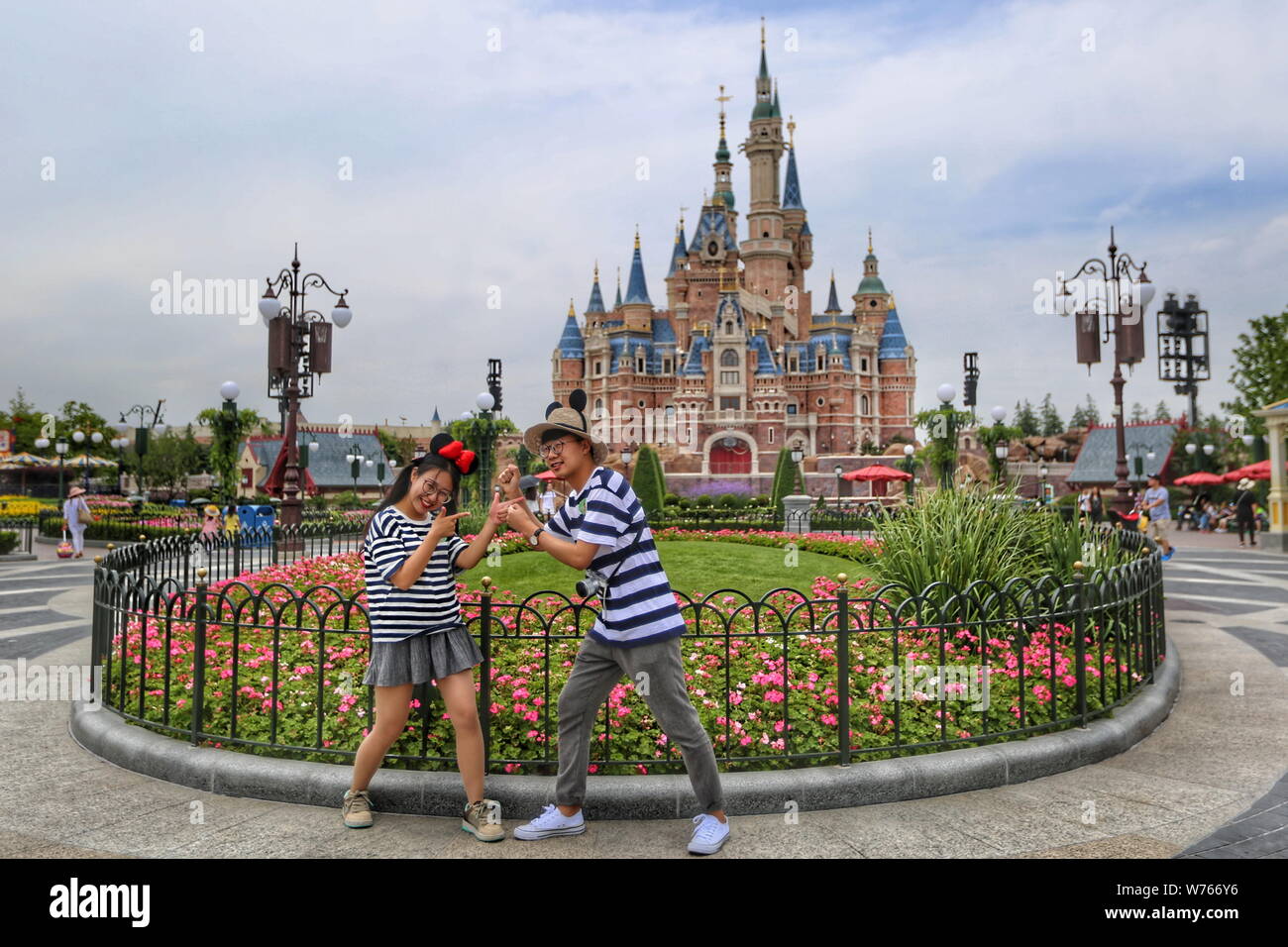 --FILE--A couple poses for photos in front of the Disney Castle in the ...