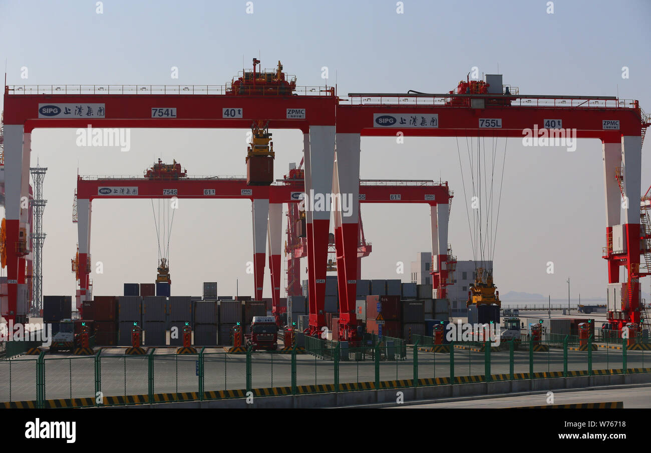 Crane vehicles lift containers at the fourth phase of the Yangshan Deep ...