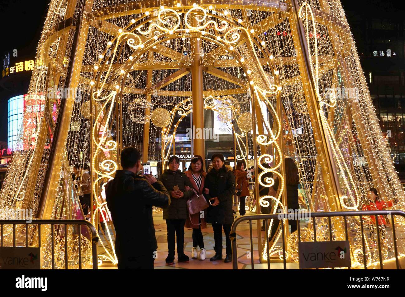 Visitors take photos with the 22-meter-tall Christmas tree decorated ...