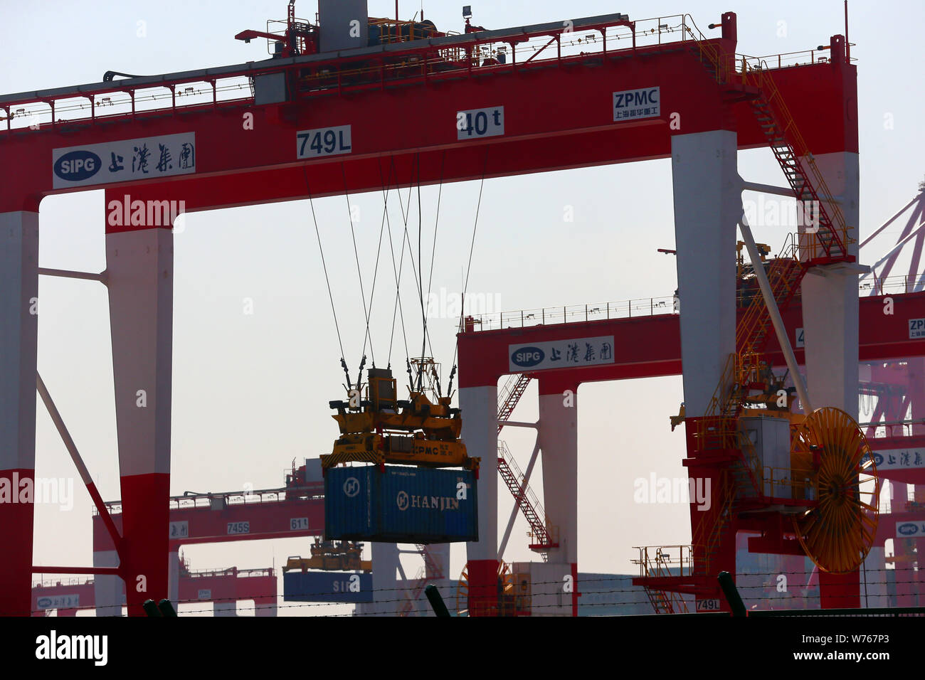 Crane vehicles lift containers at the fourth phase of the Yangshan Deep ...