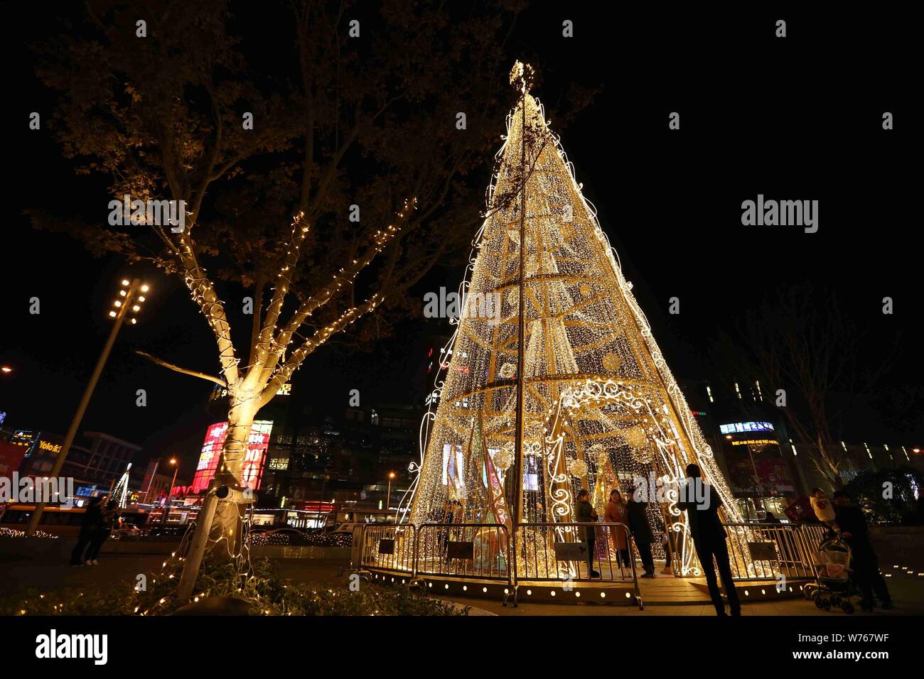 Visitors take photos with the 22-meter-tall Christmas tree decorated ...