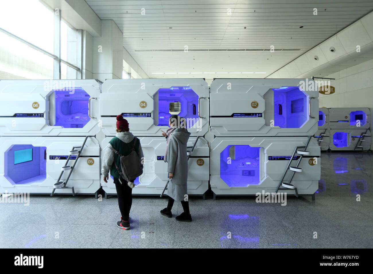 Passengers look at sleeping capsules in the arrival hall of Terminal 3 ...