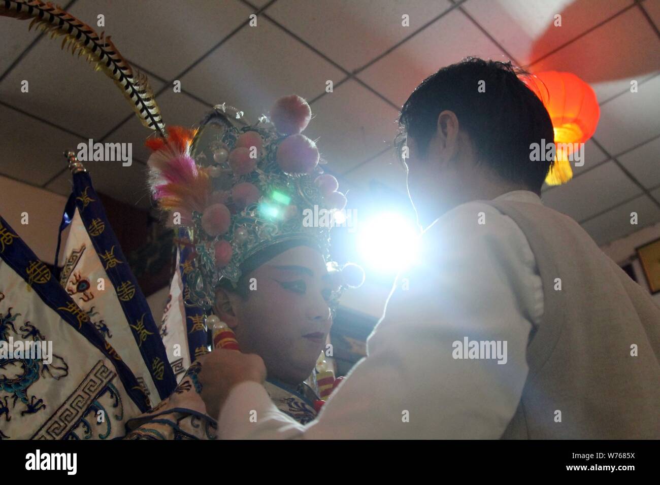 --FILE--A visitor finishes his makeup with the help of a Chinese ...